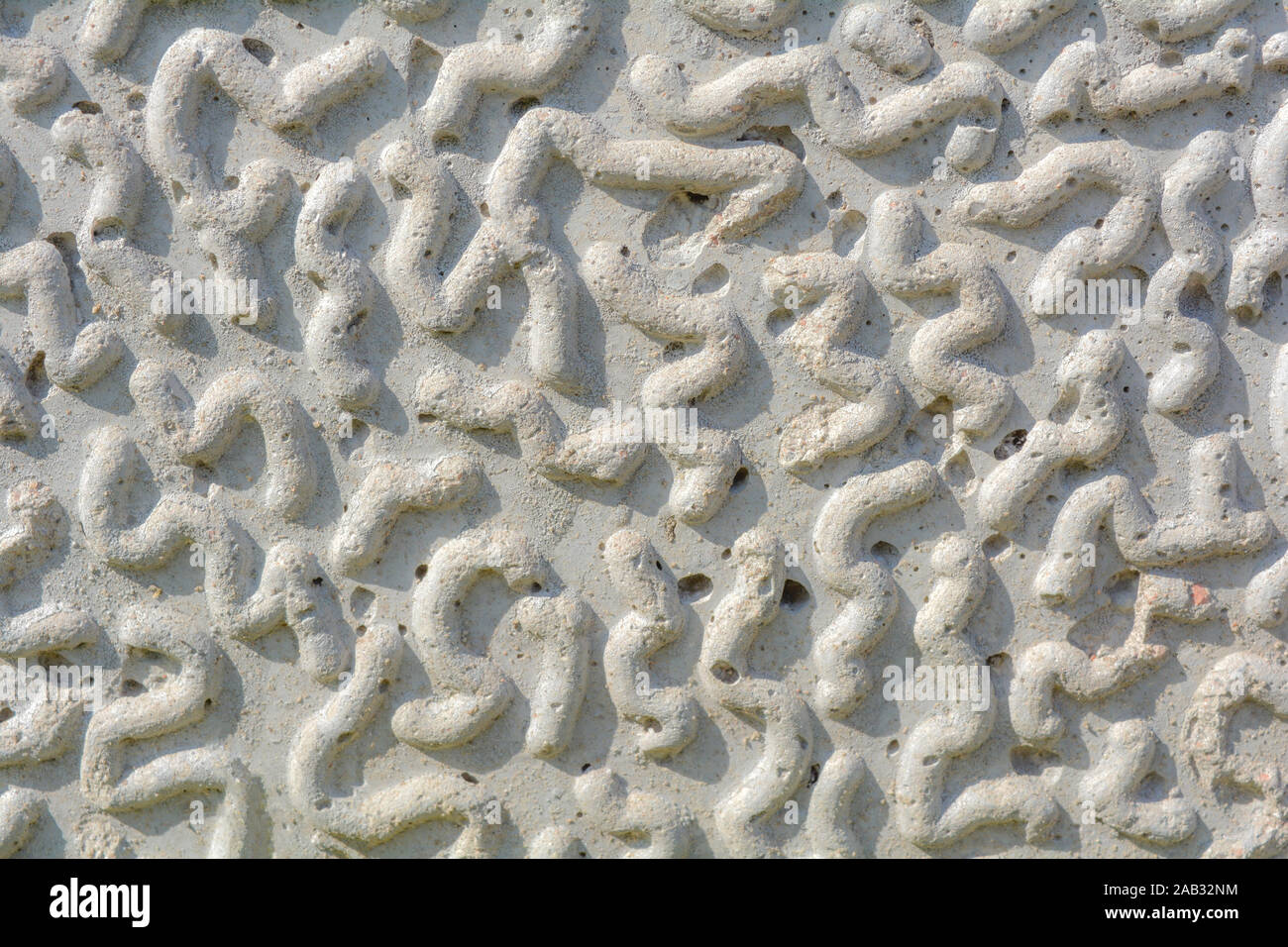 Close-up of abstract carved stone texture with worm or caterpillar ...