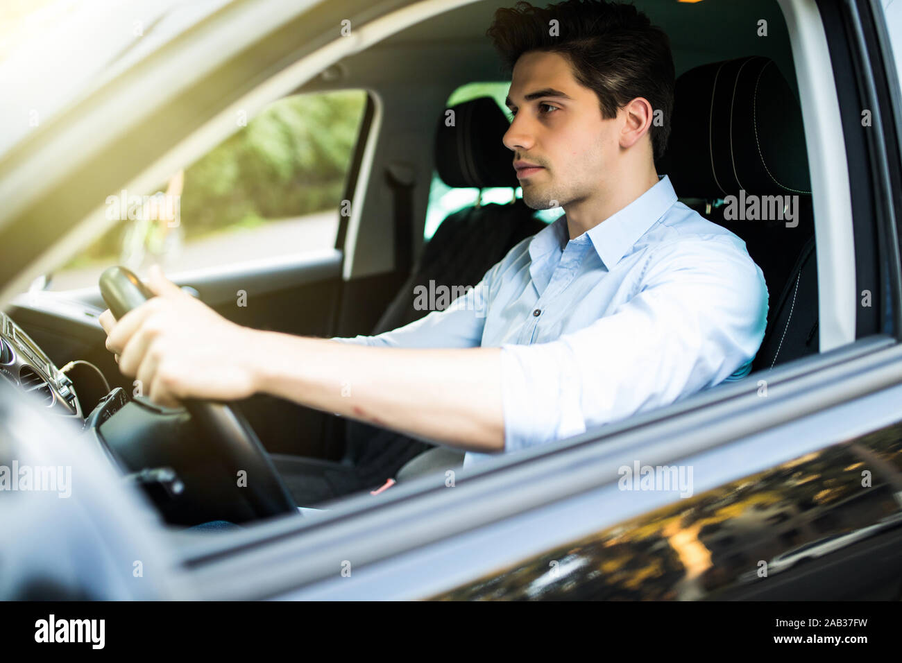 Portrait of an handsome guy driving his car Stock Photo - Alamy