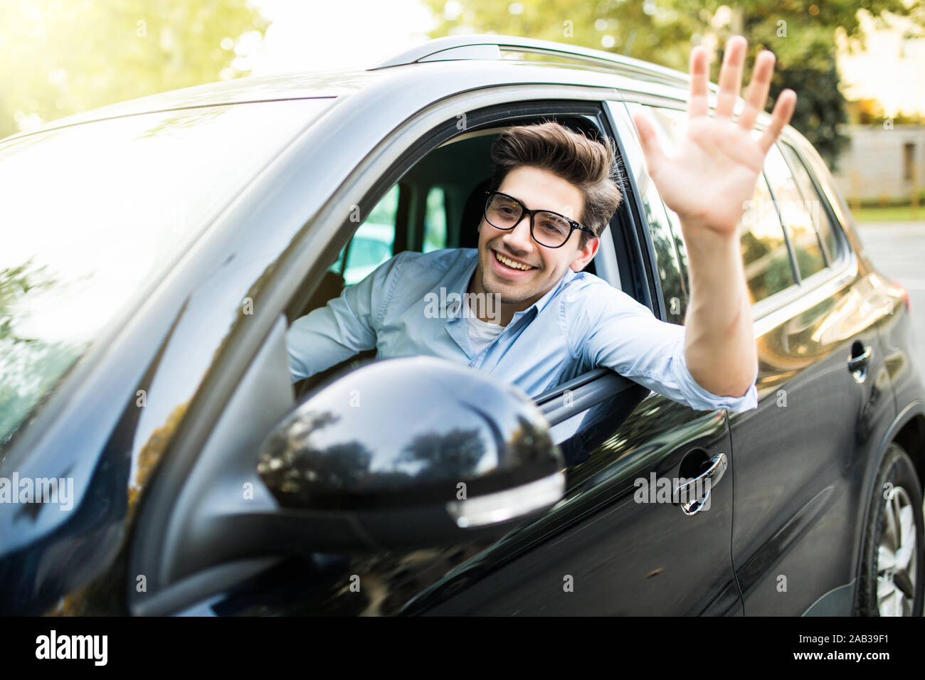 selective focus of happy man driving car and waving hand Stock Photo ...