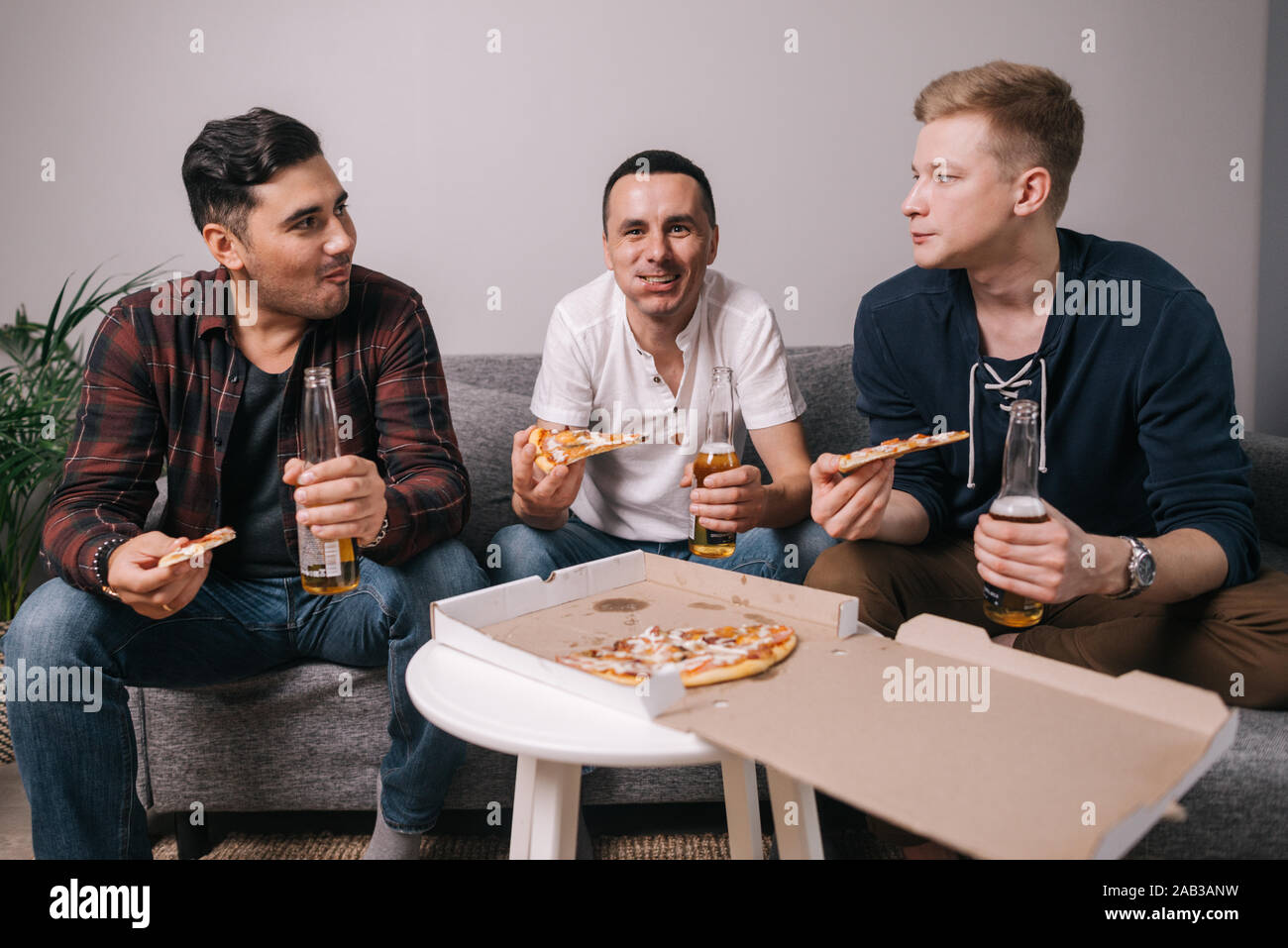 Bunch of friends eating pizza from table at the home Stock Photo - Alamy