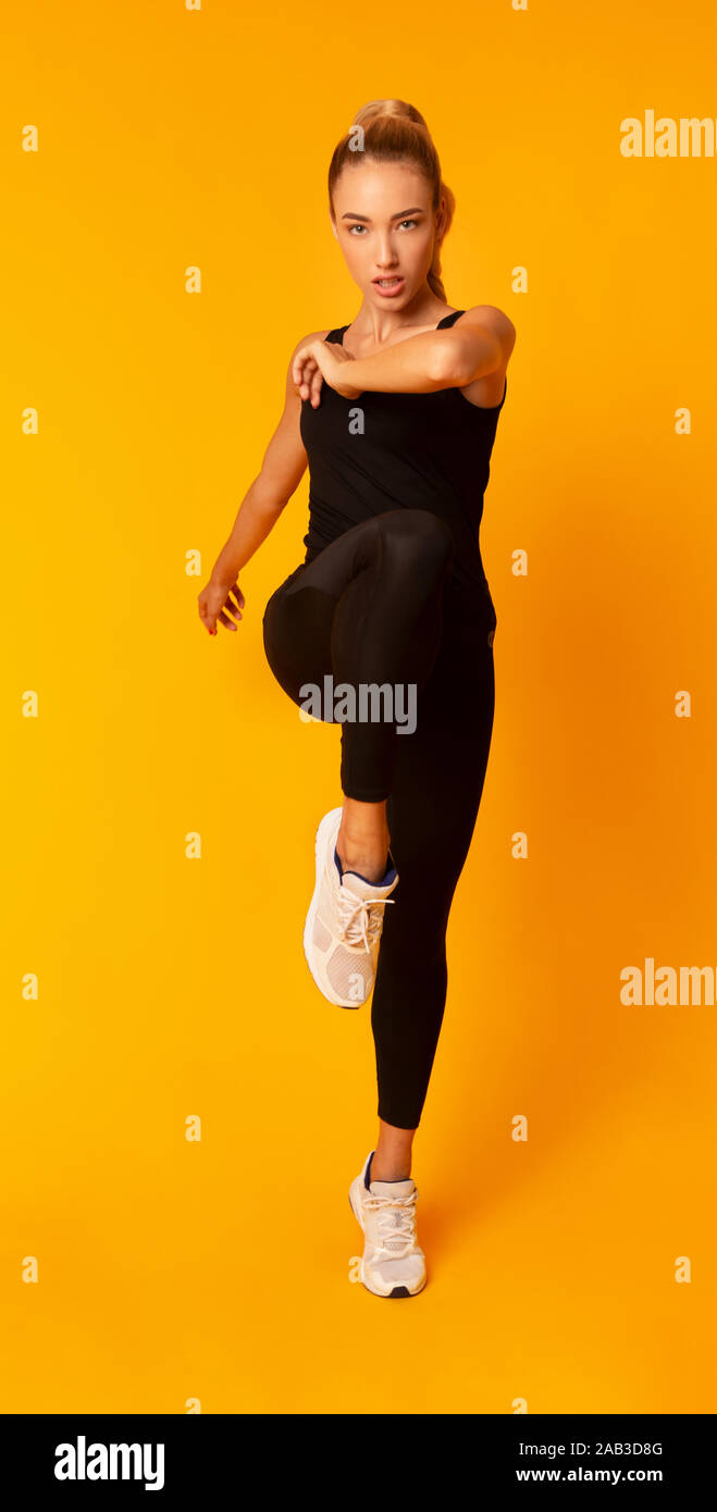 Determined Girl Jumping Over Yellow Background, Full Length Stock Photo ...