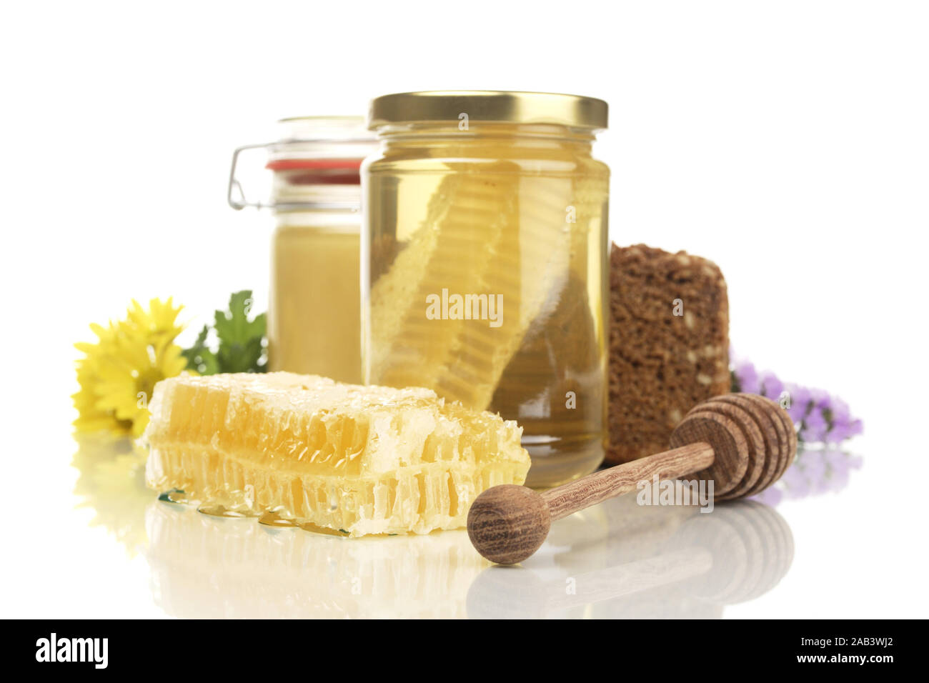 Honiggl‰ser mit Bienenwabe, Vollkornbrot, Honiglˆffel und Blumen ...