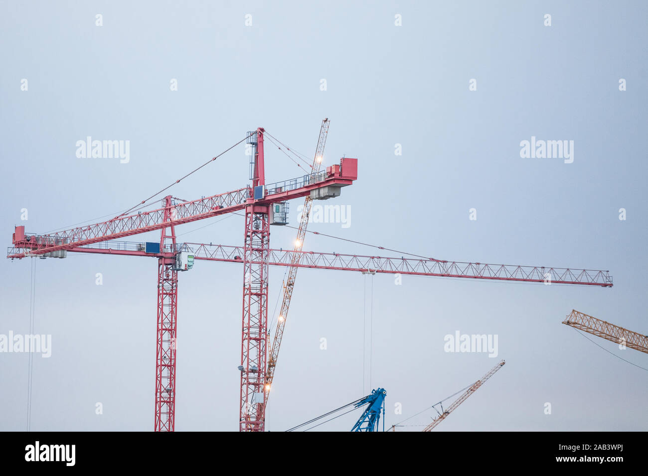 Group of cranes on a construction site, in front of a building being ...