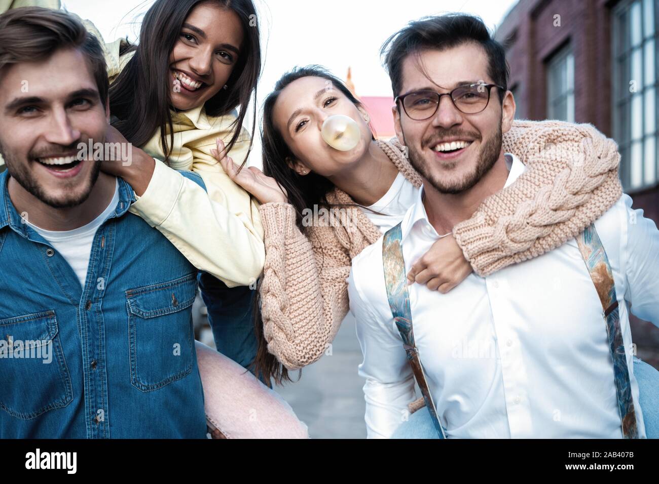 Two happy couple having fun piggyback ride outdoor, smiling happy ...