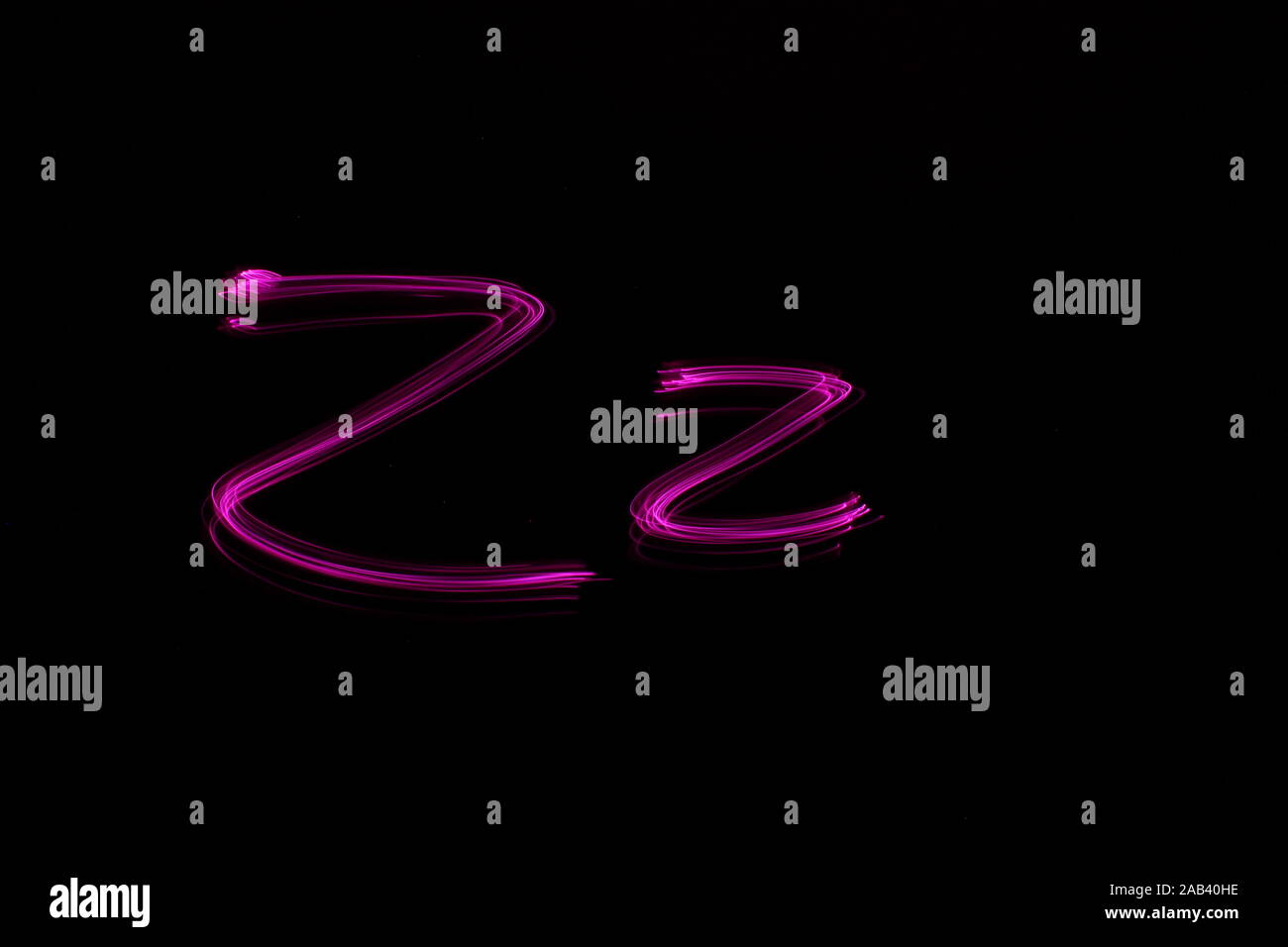 Long exposure photograph of the letter z in pink neon color, in upper ...