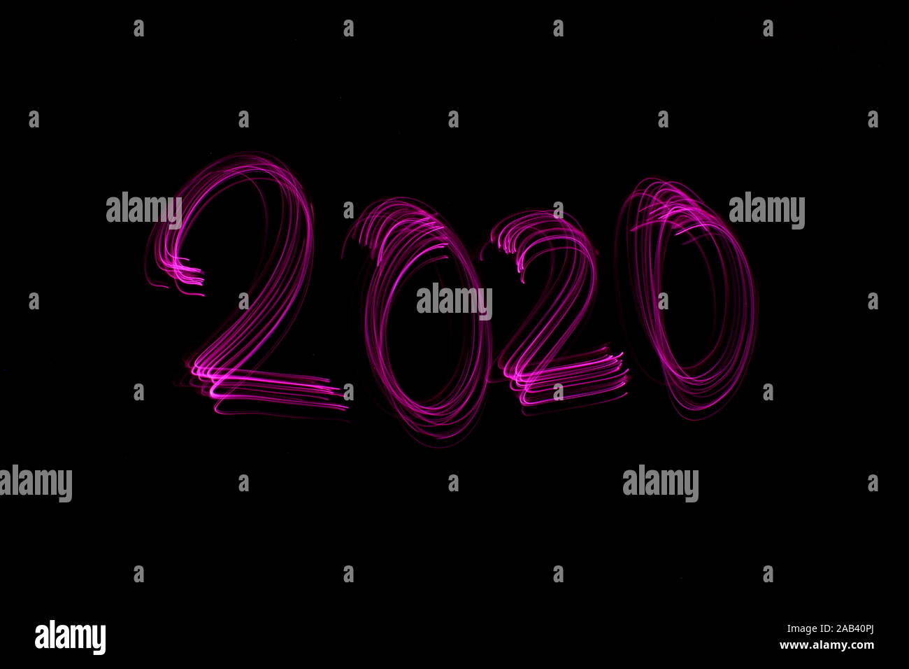 Long exposure photograph of the digits '2020' in pink neon colour in an ...