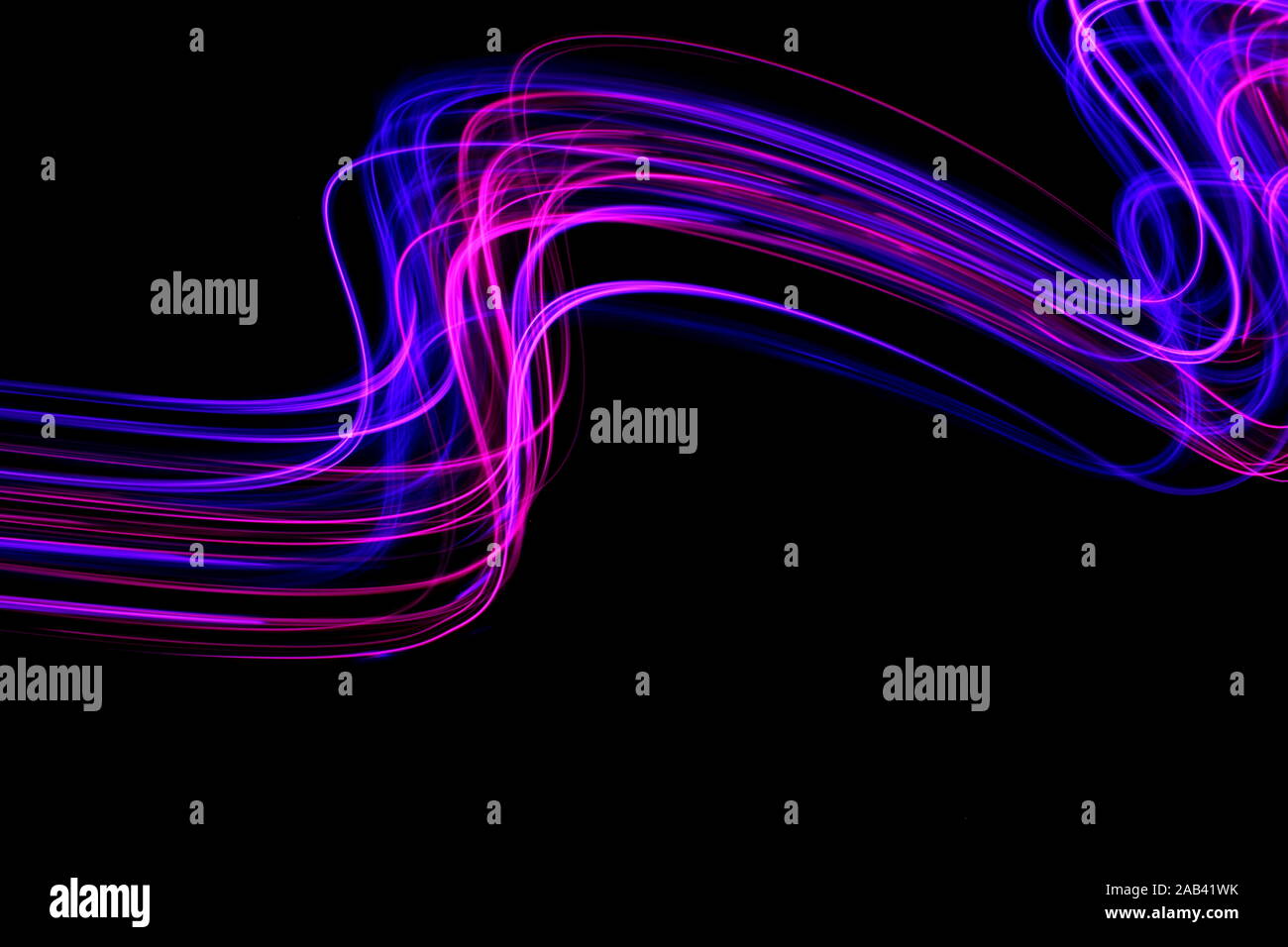 Long exposure photograph of pink purple neon color in abstract swirls ...