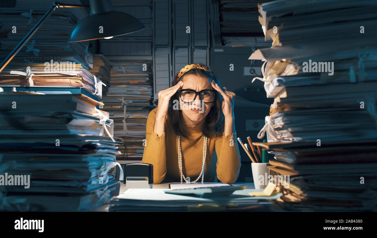 Confused puzzled female office worker sitting at desk and thinking, she ...