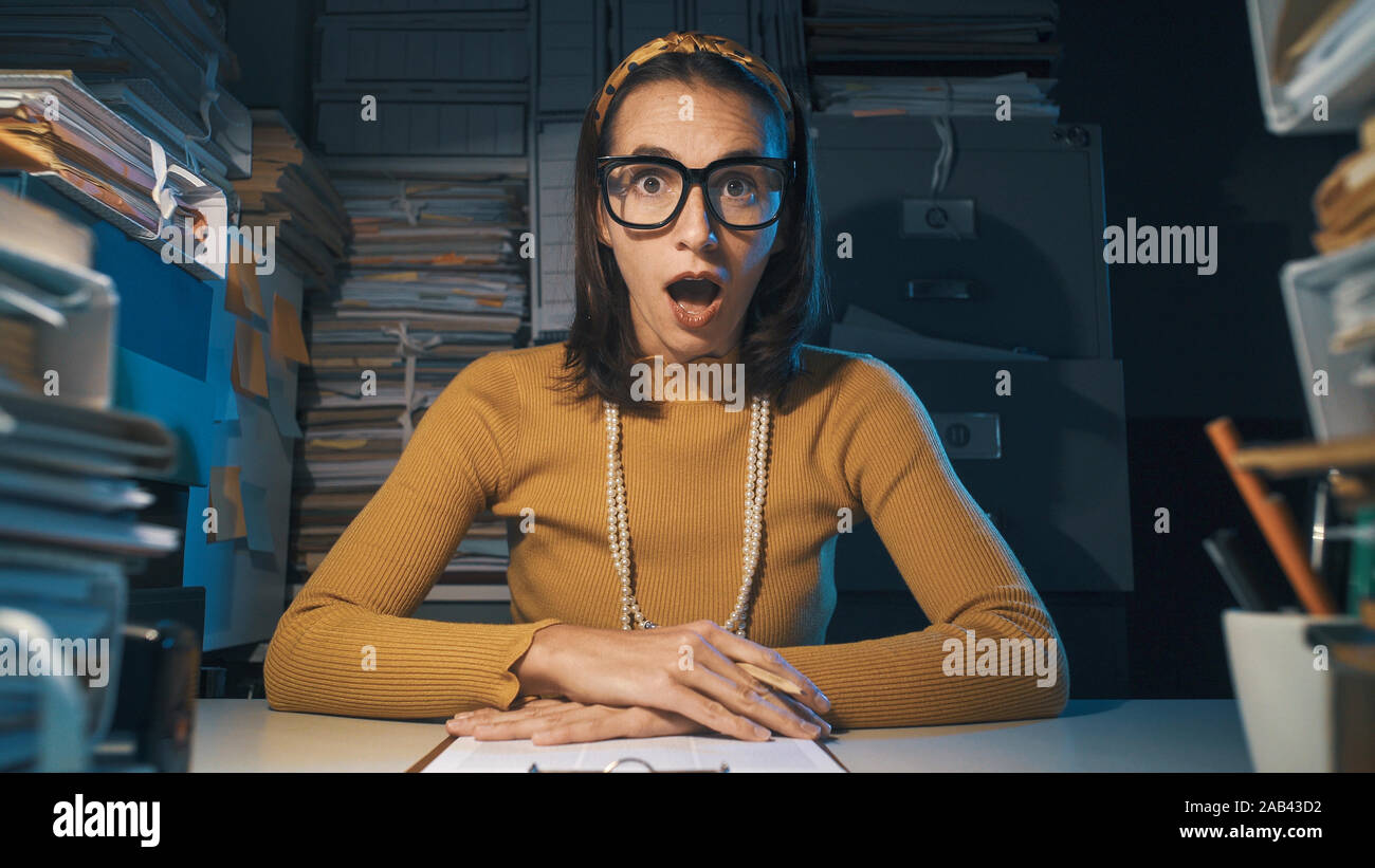 Shocked panicked businesswoman sitting at office desk and working, she ...