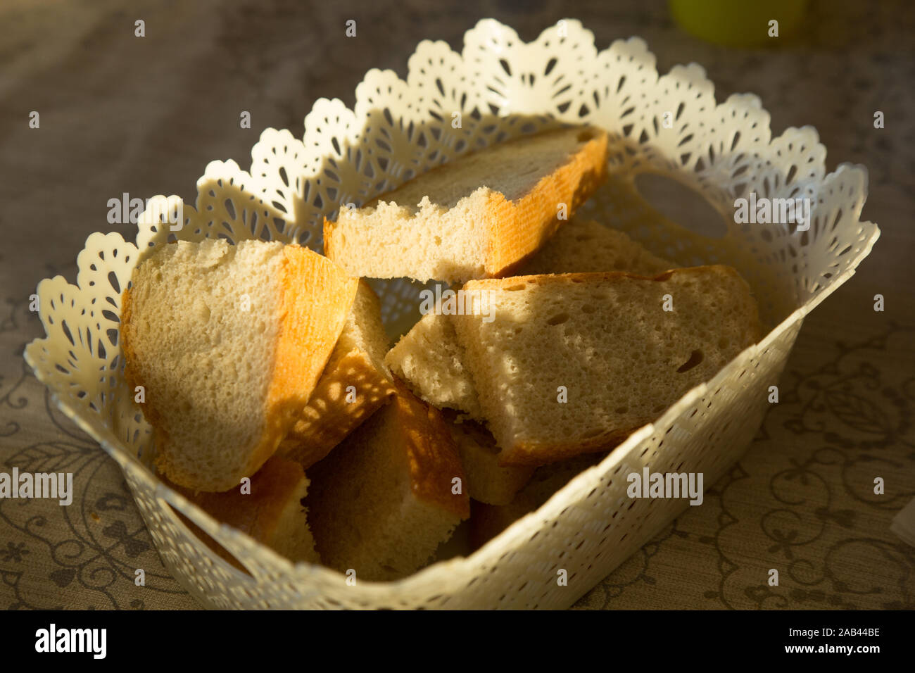 Slices of bread in the plastic lace bowl and sun rays on it Stock Photo ...