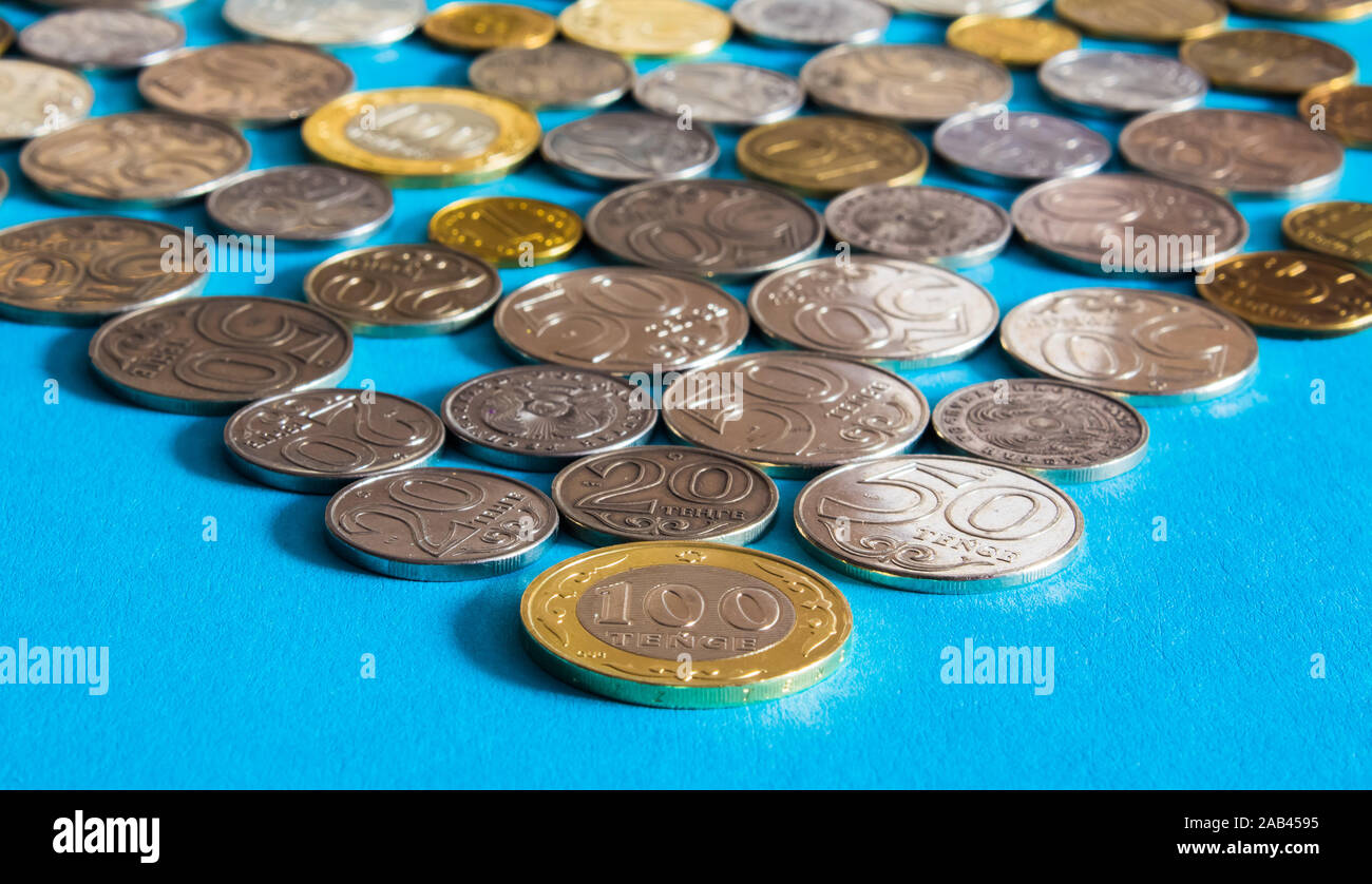 Tenge on a blue background with coins. Tenge coins of Kazakhstan Stock ...