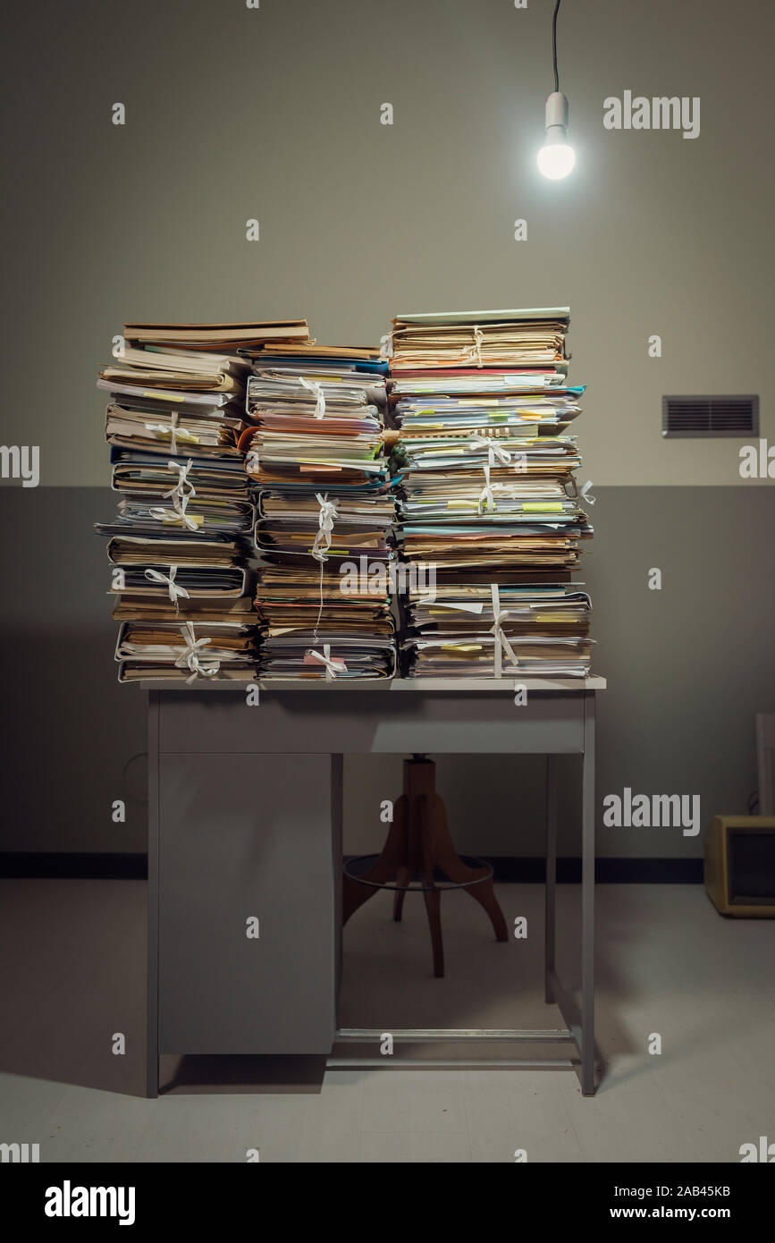 Piles of paperwork and files on a small desk, taxes and overwork ...