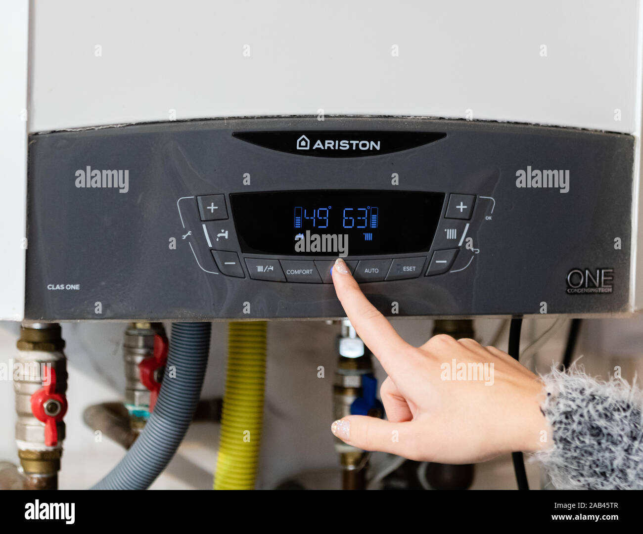 Girl hand setting temperature to heating system. Central heating ...