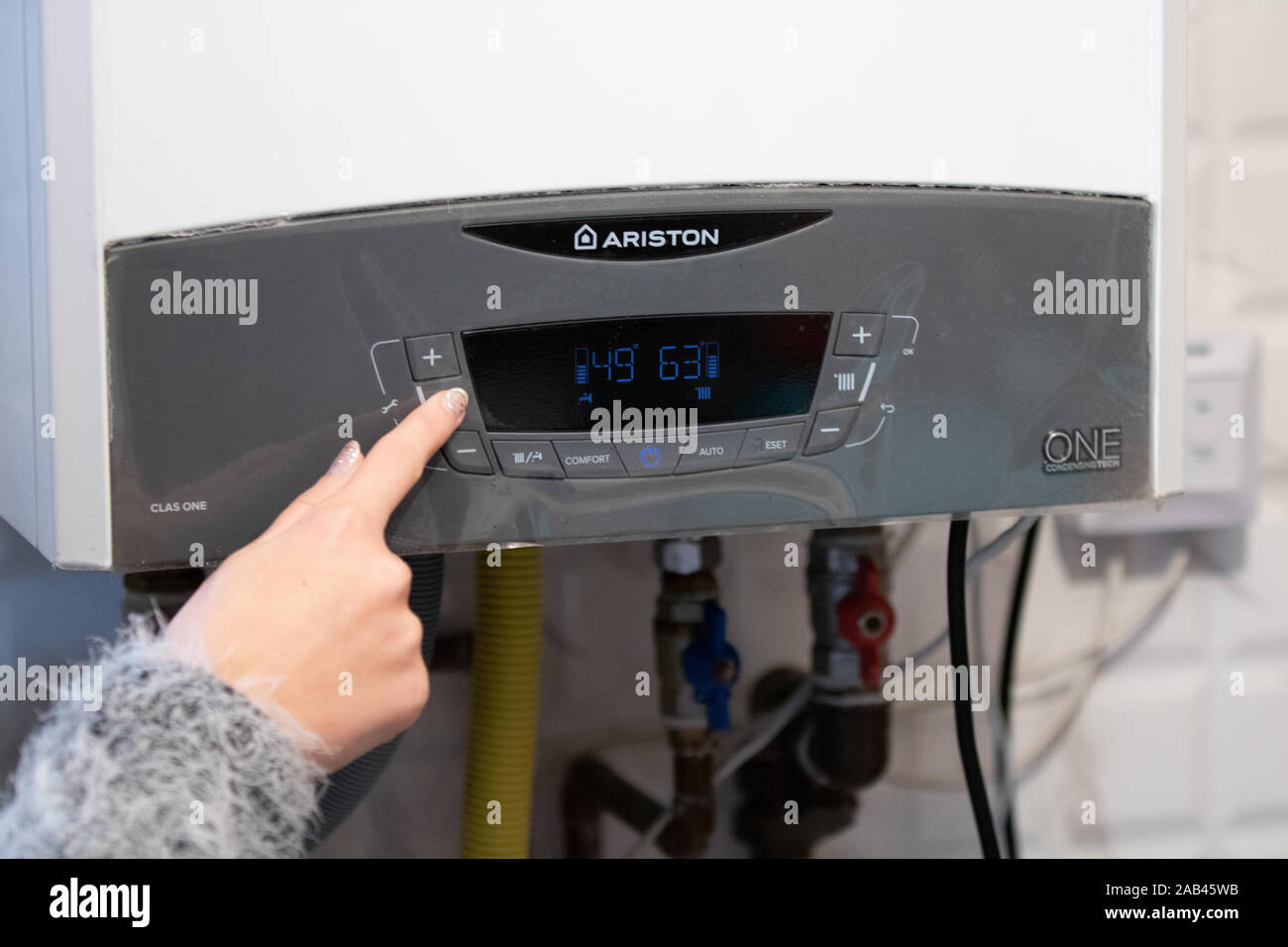 Girl hand setting temperature to heating system. Central heating ...