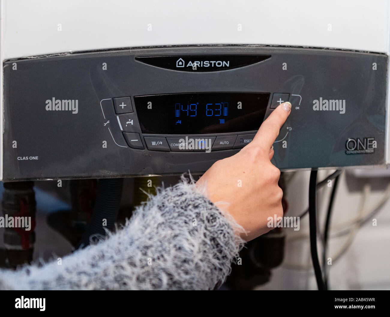 Girl hand setting temperature to heating system. Central heating ...