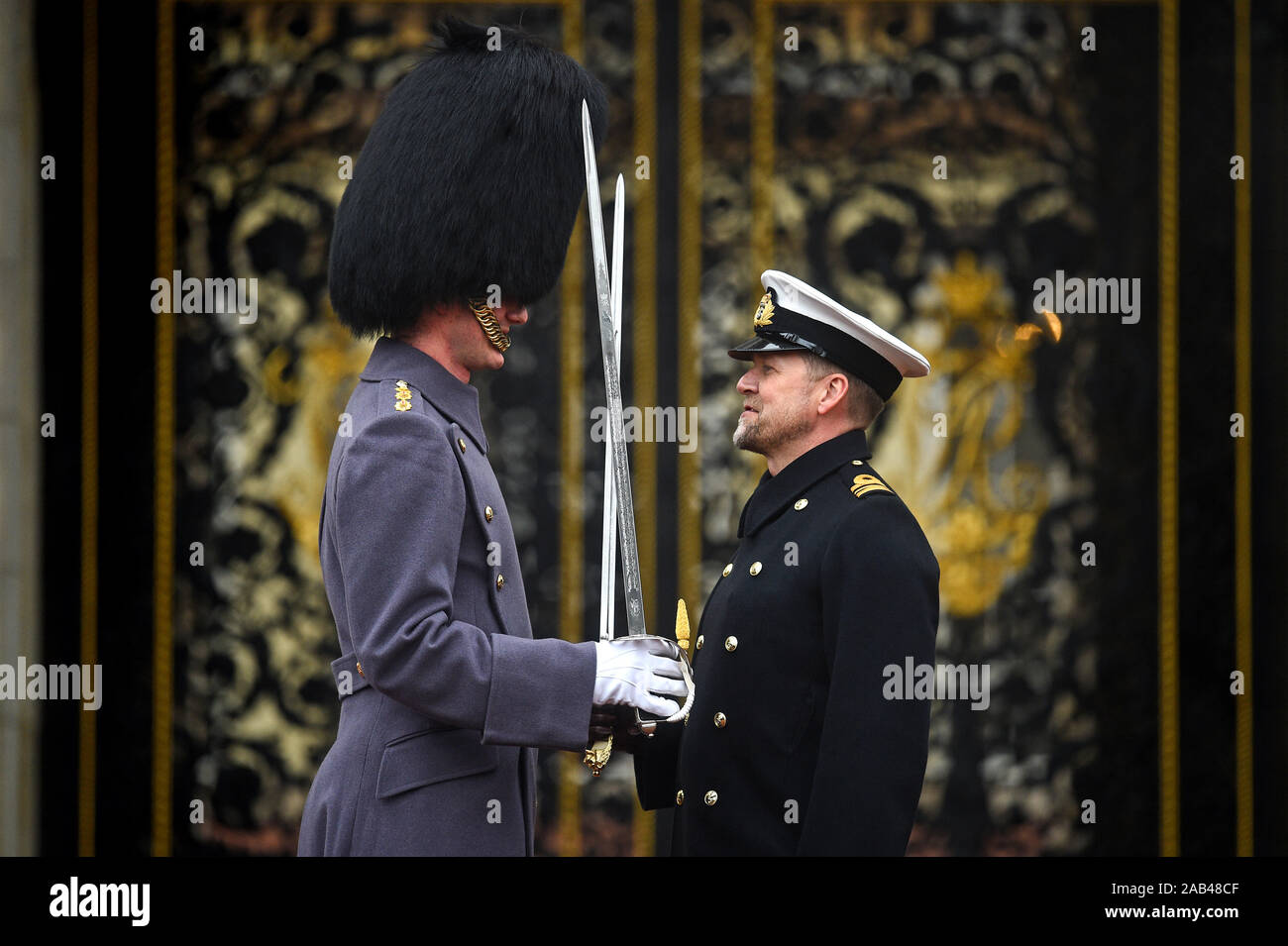 A Royal Navy officer (right) alongside a guardsman, as sailors from the ...