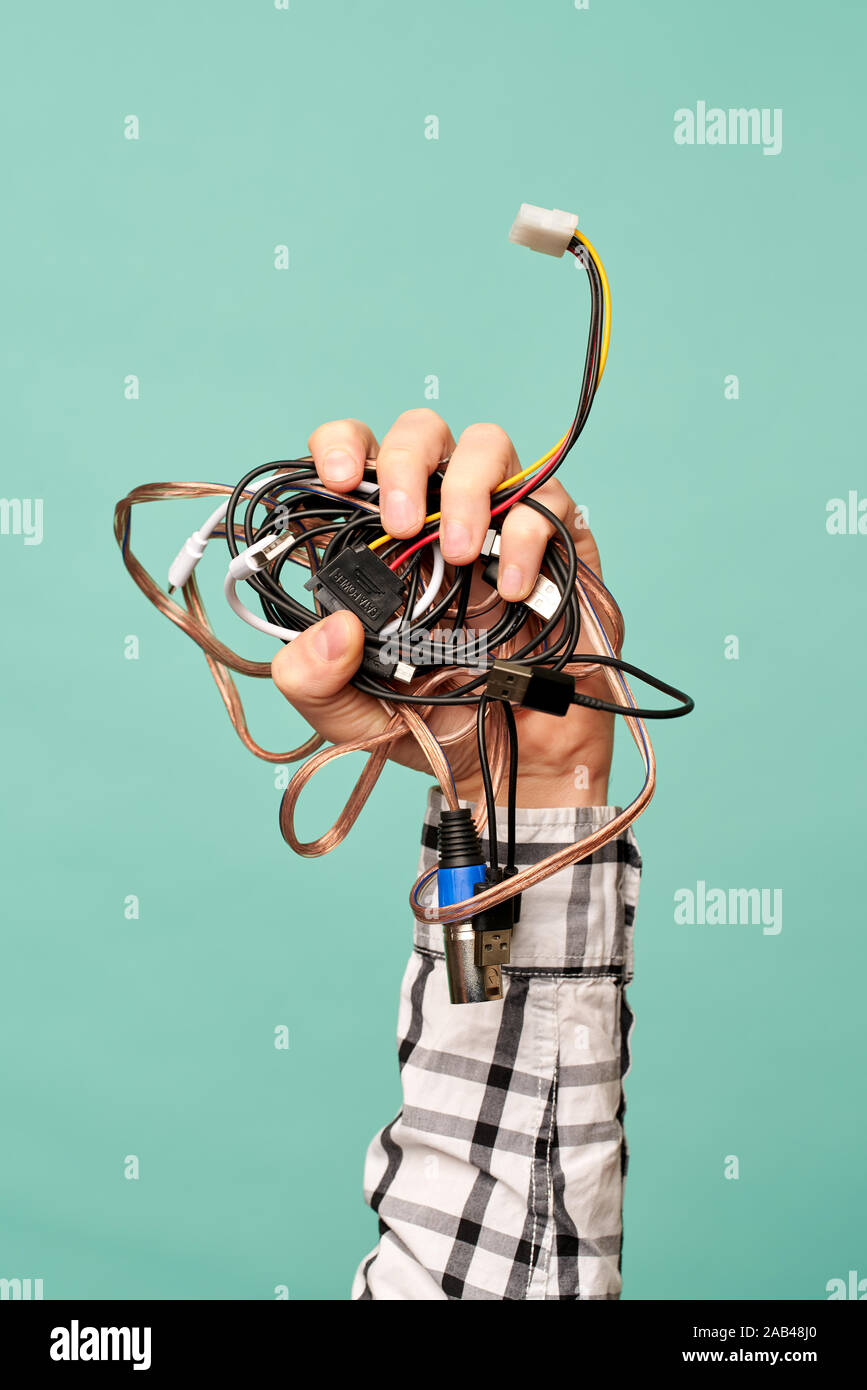 Male hand holds electrical waste on blank blue background ...