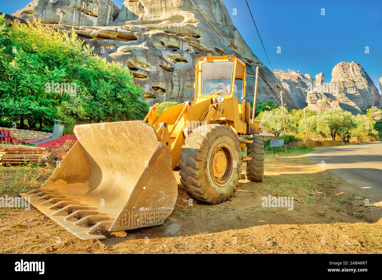 Side view of yellow excavator for building work along road in a ...