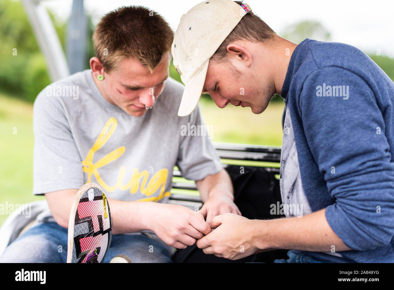 Friends hanging out together at the skatepark, chatting while having a ...
