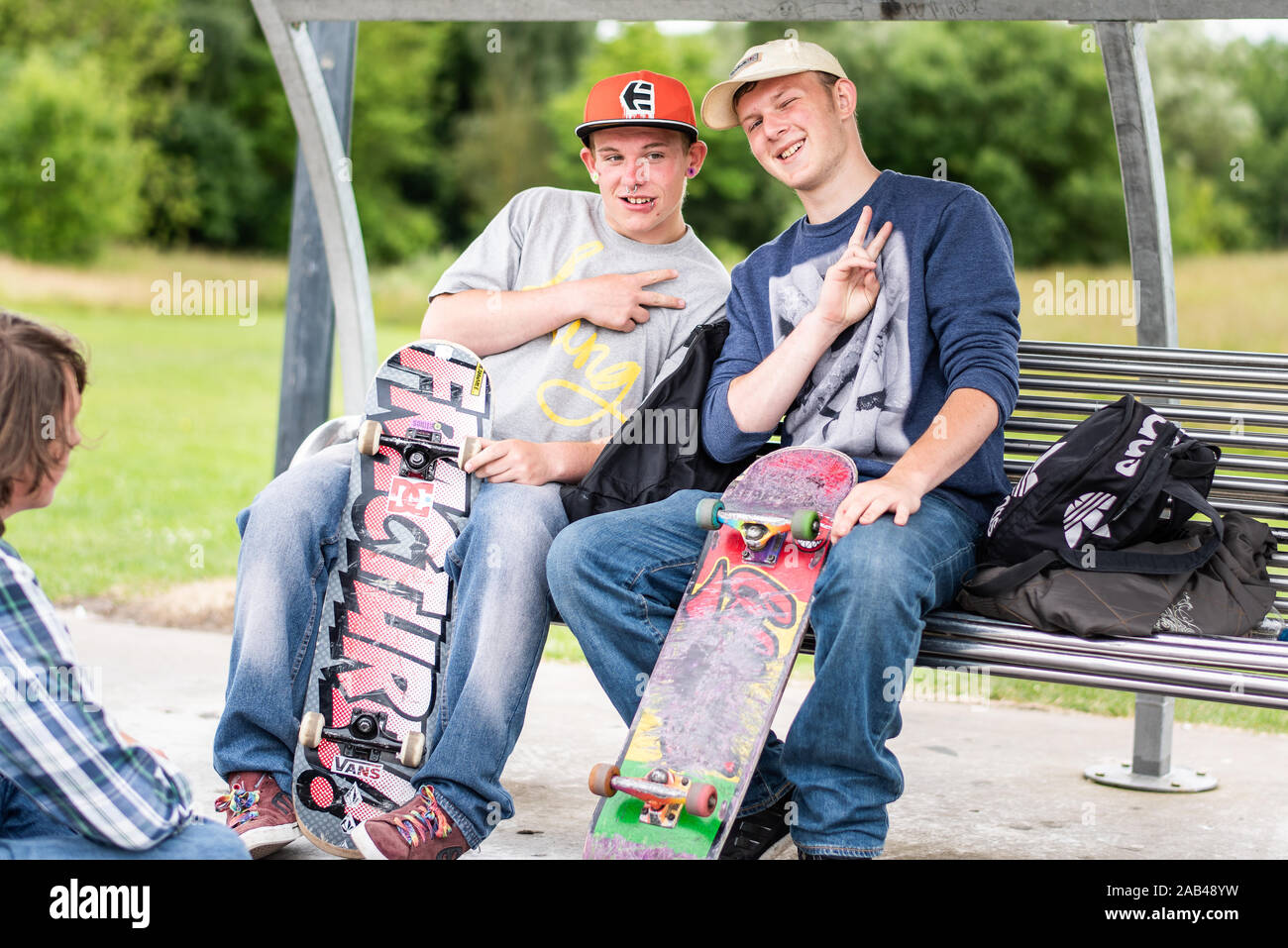 Friends hanging out together at the skatepark, chatting while having a ...