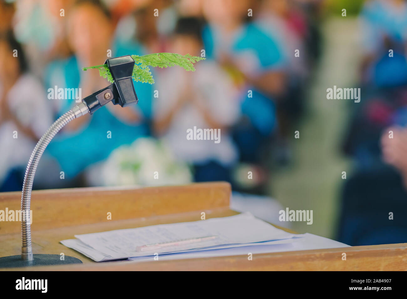 Artificial leaf inserted in the desktop microphone stand on podium in ...
