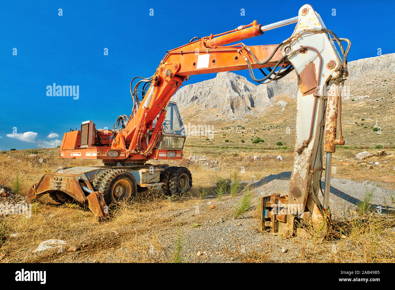 Side view of long arm of excavator in a mine with sand, earth and ...
