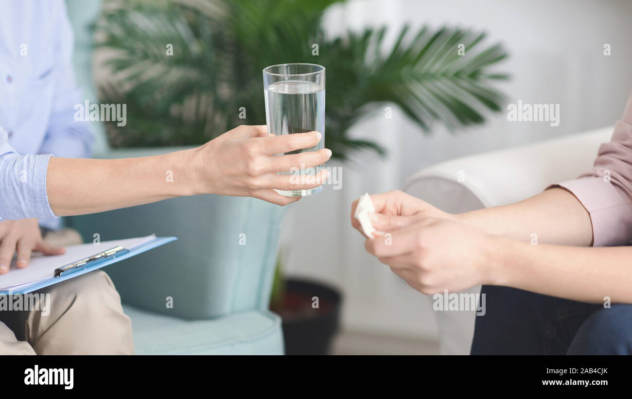 Psychologist giving glass of water to patient Stock Photo - Alamy