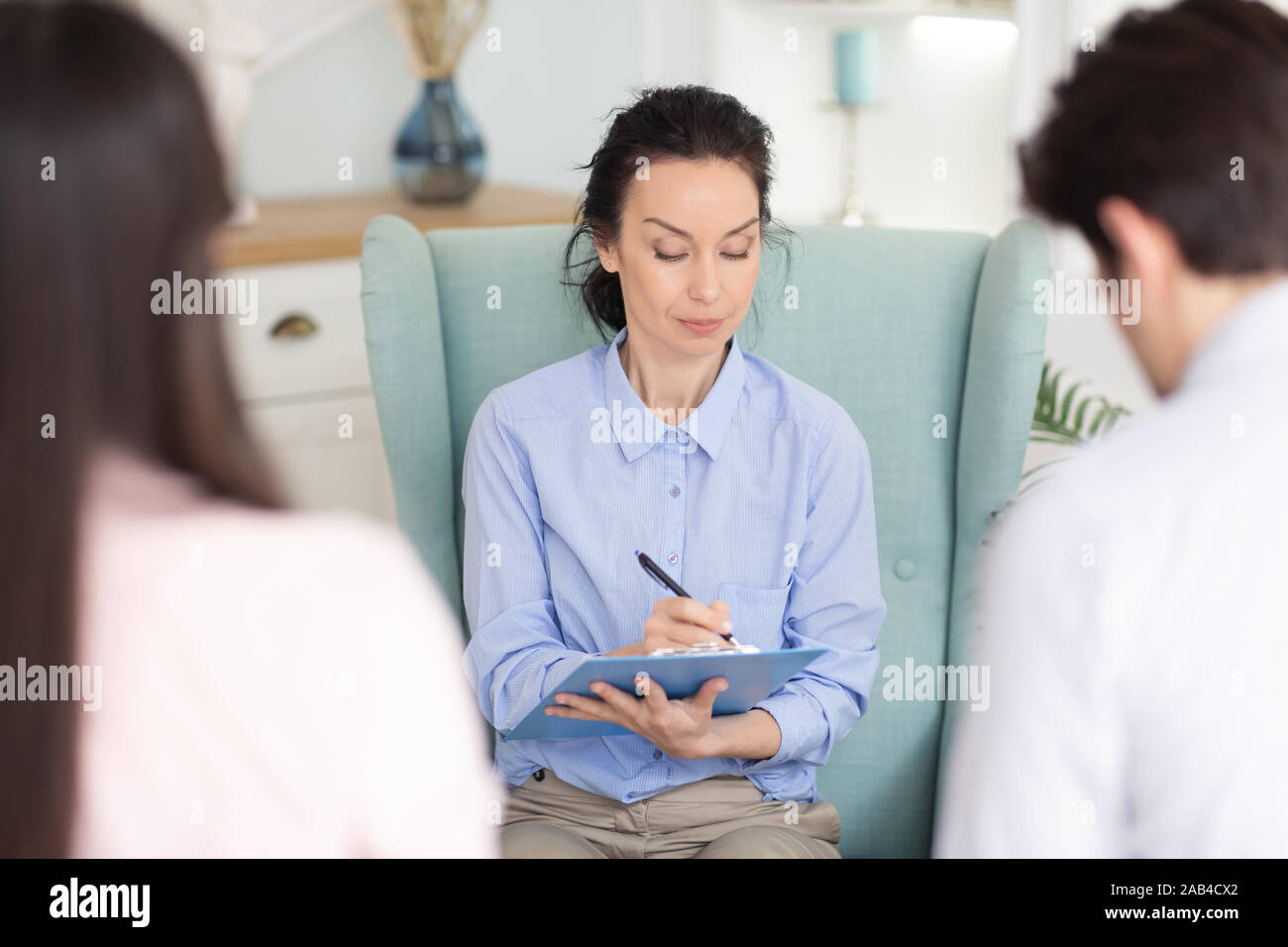 Therapist talking making notes during hi-res stock photography and ...