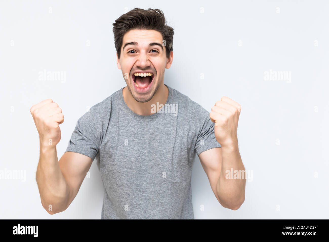 Portrait Of Smiling Man With The Fists Up Against A White Background ...