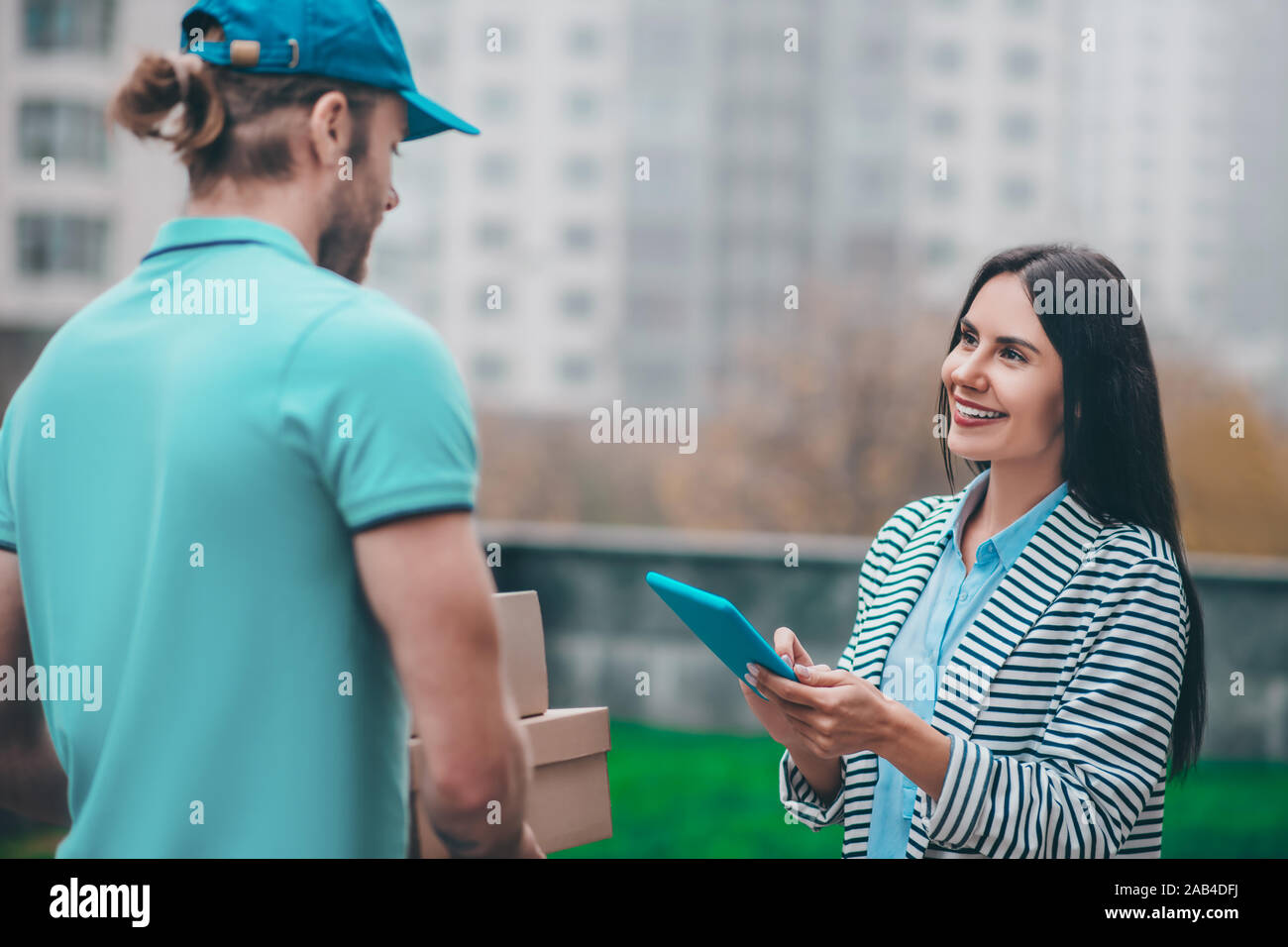 Beautiful businesswoman enjoying communication with delivery man Stock ...