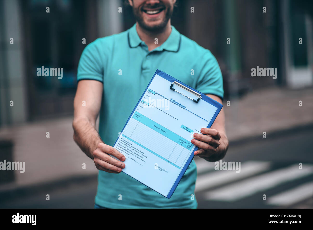 Bearded delivery man holding invoice after delivering product Stock ...