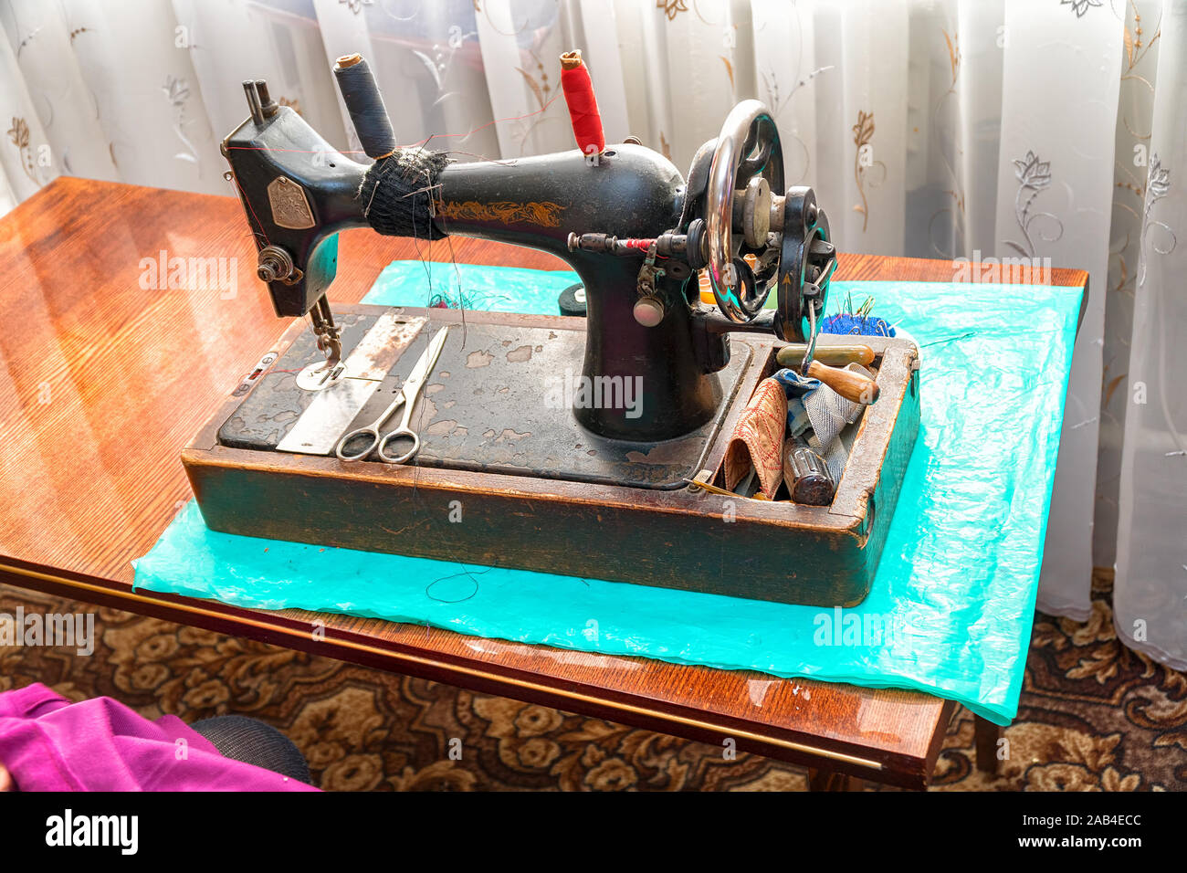 Vintage sewing machine and scissors on the table. Black and white photo ...