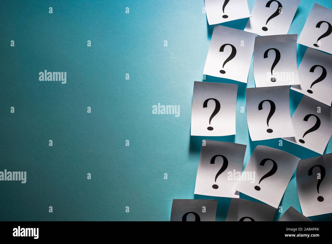 Side border of rows of printed question marks on white cards over a ...