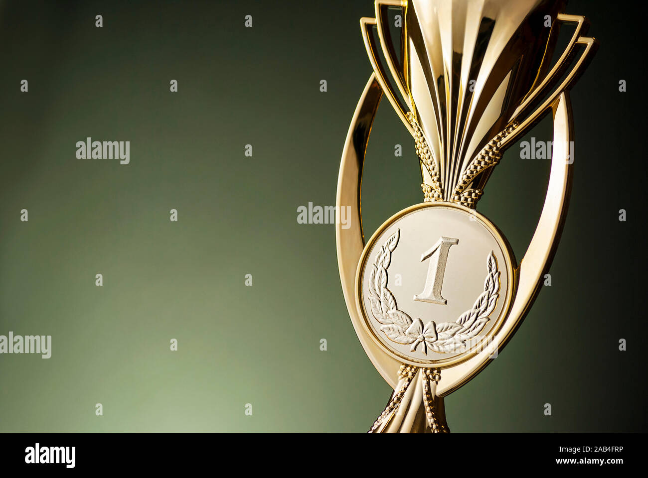 Gold first placed winners championship trophy award over a green ...