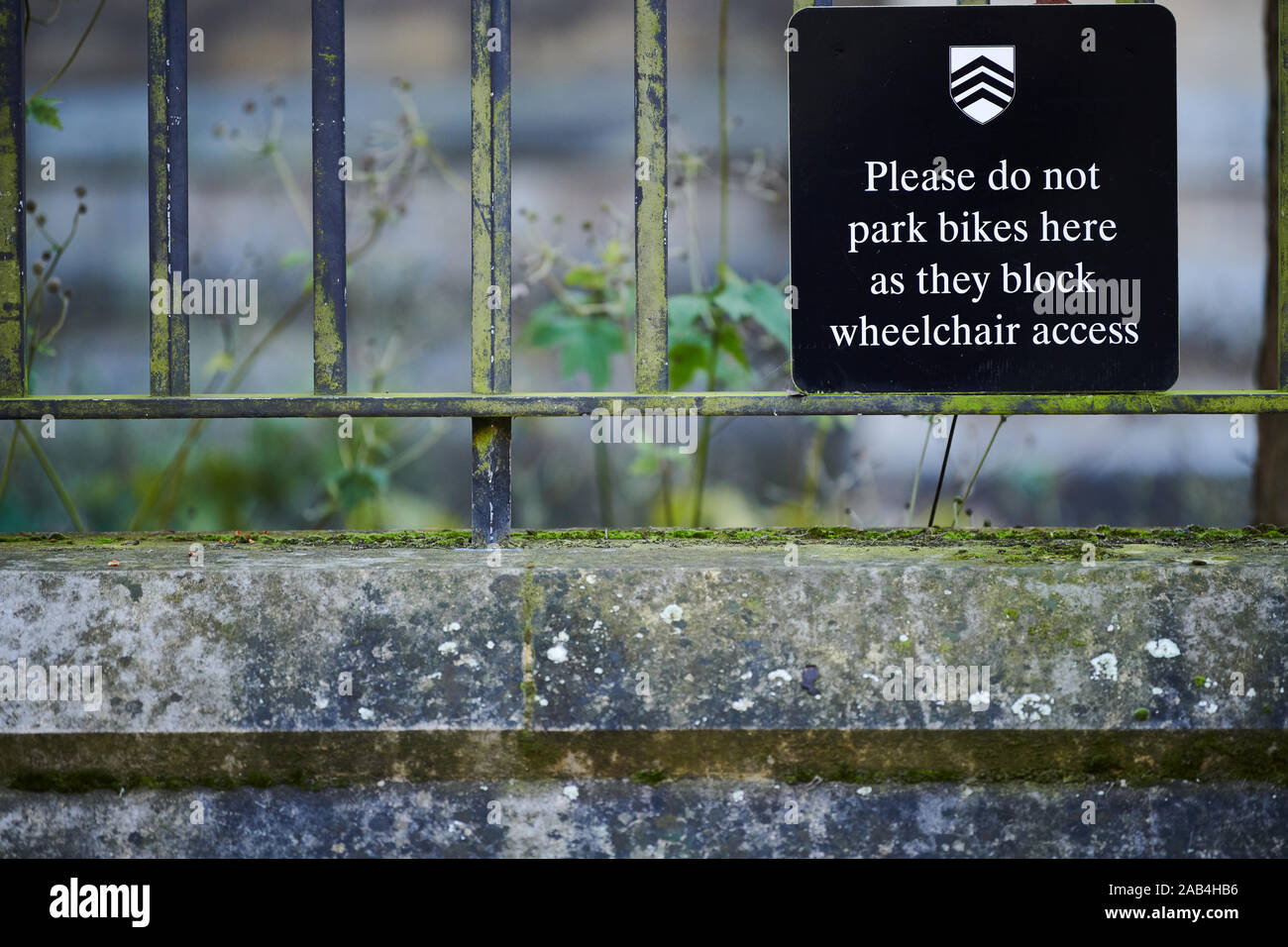 A polite request notice not to park bikes next to the wall and railings ...
