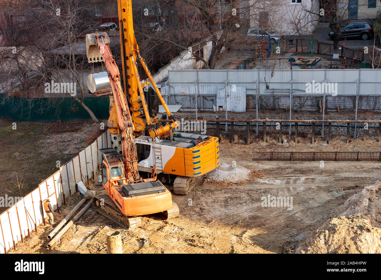 Heavy crawler-mounted construction equipment works on a fenced ...