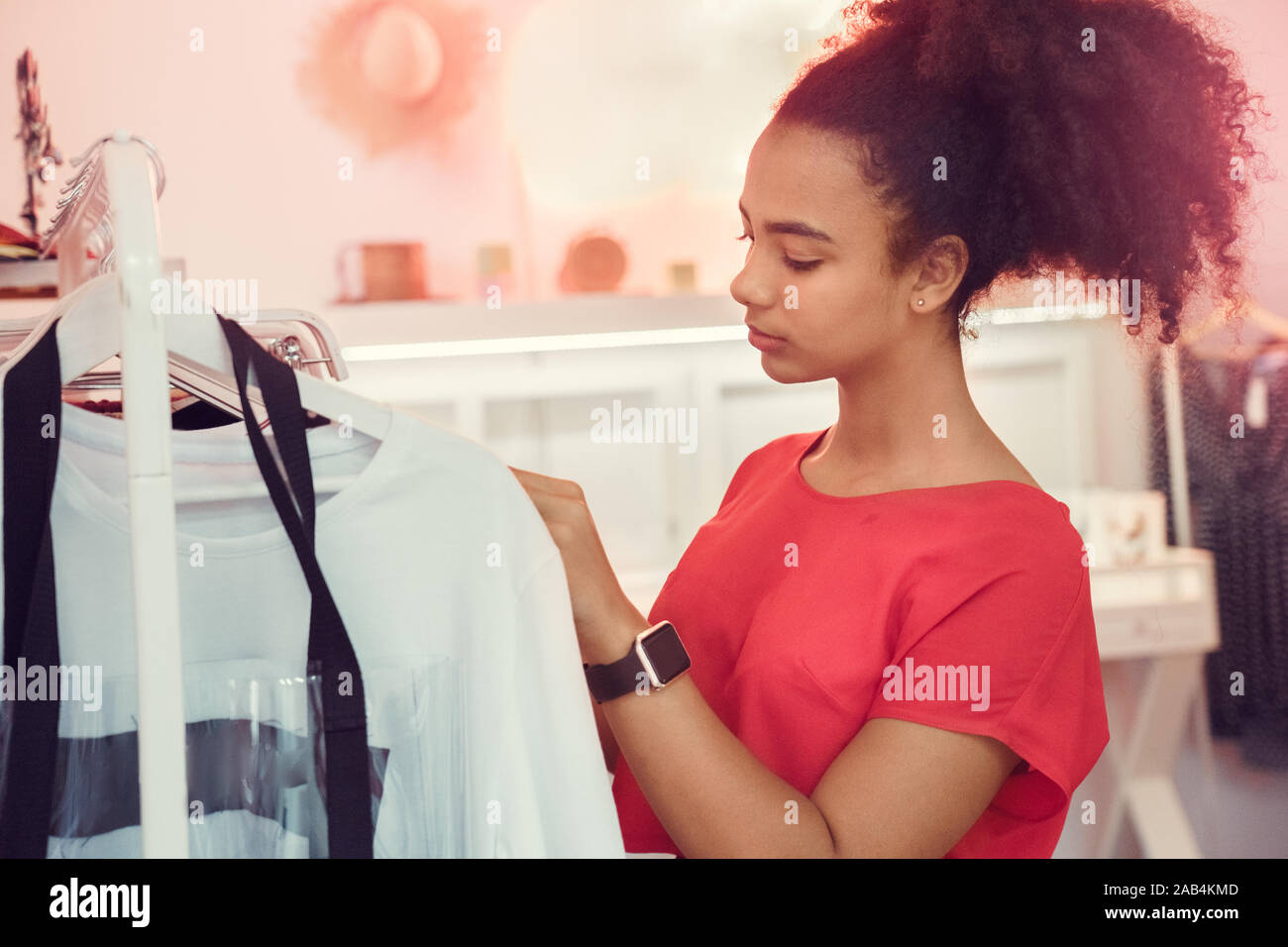 Choosing Clothes. African teenager girl standing choosing clothes from ...