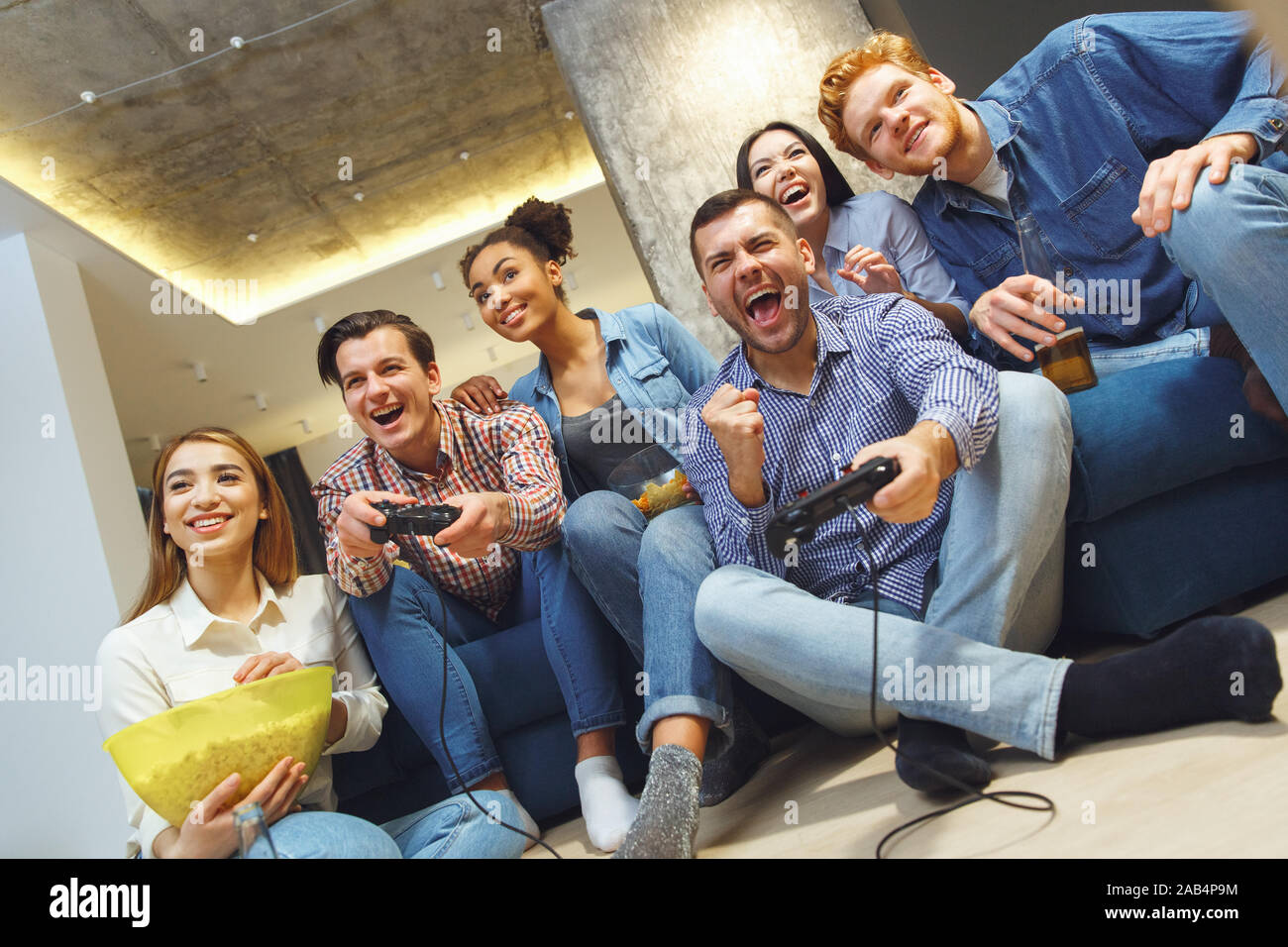 Group of friends having party indoors fun together playing football on ...