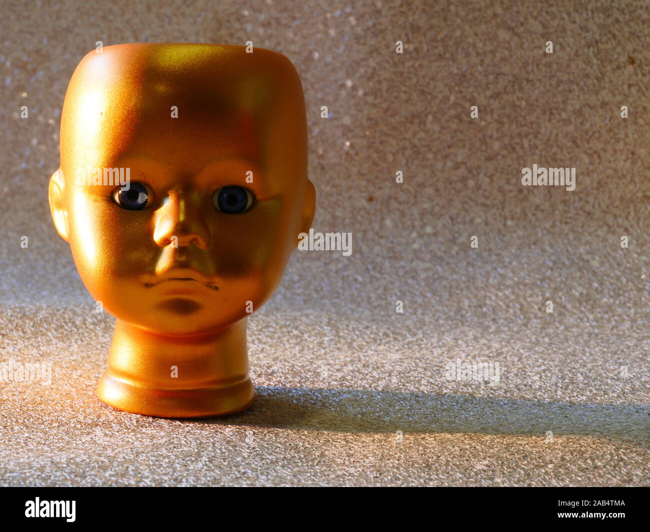 Doll head, gold, facing forward part side lit face Stock Photo - Alamy