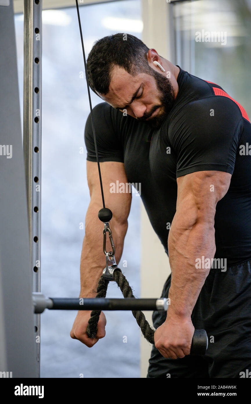 strong healthy young bearded man in black sportswear during workout for ...