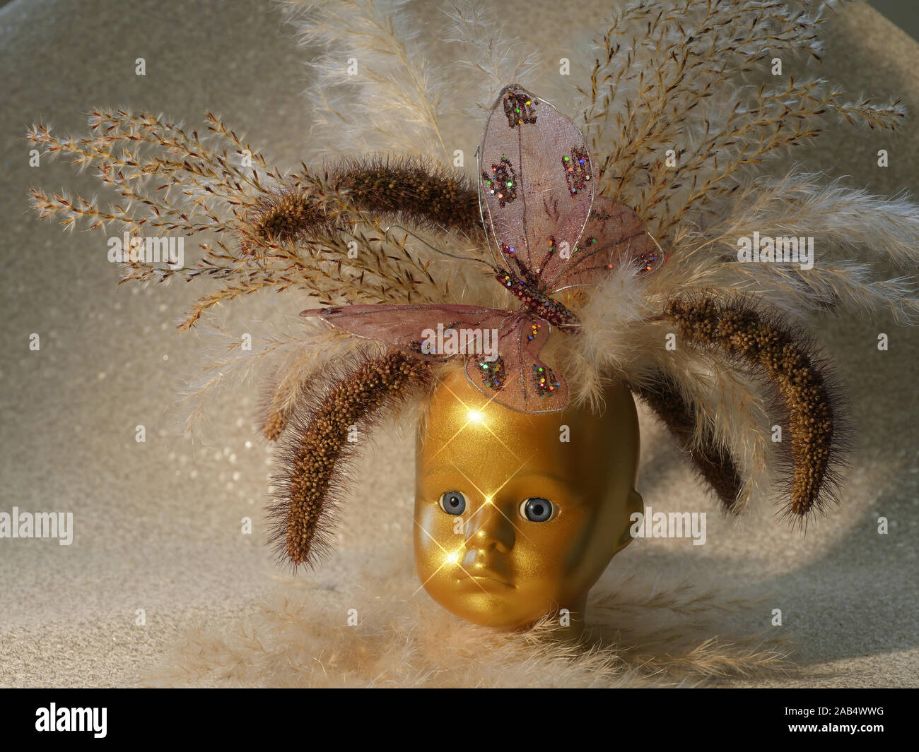 Doll head, gold face, with ornamental Carnival headdress made of ...