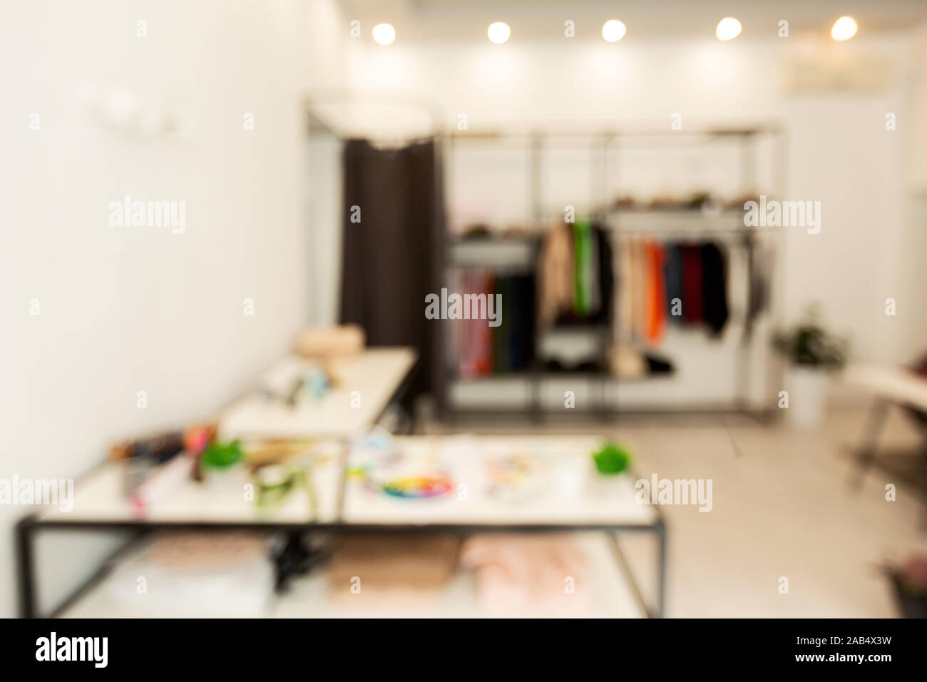 Blurred Tailor's Workplace Background With Clothes Hangers And Sewing ...