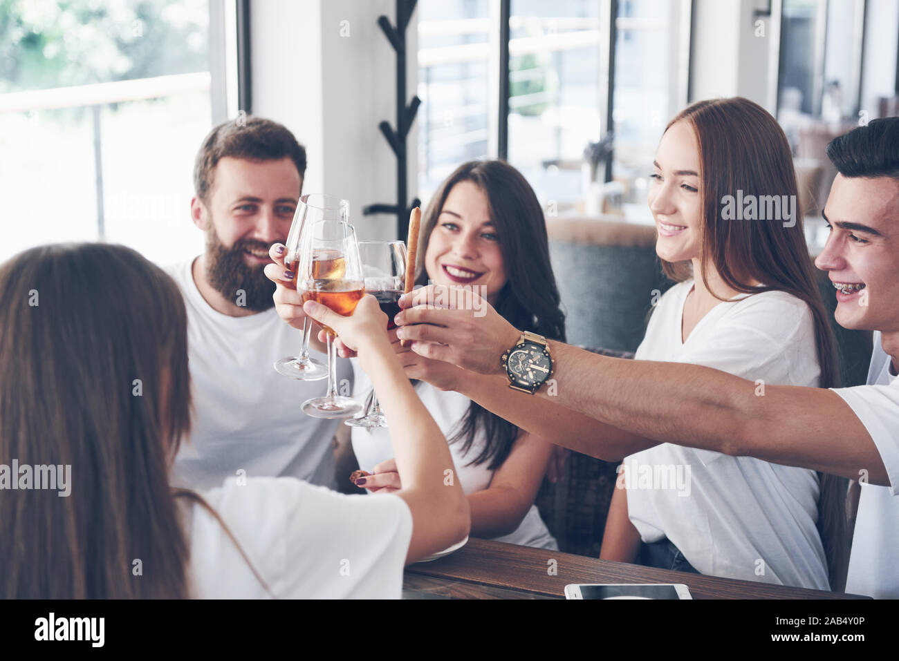 Friends got together by table with delicious food with glasses of red ...