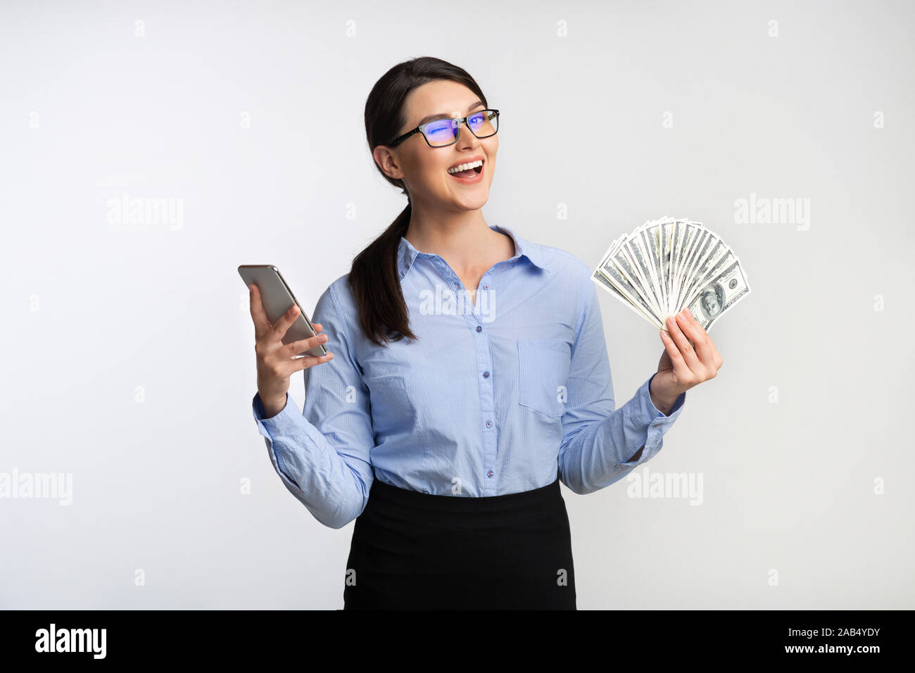 Business Girl Holding Smartphone And Money Winking At Camera, Studio ...