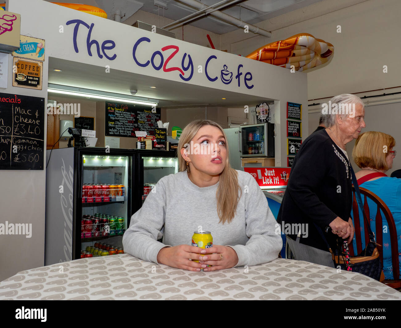 A young woman eats a full English breakfast in an indoor cafe Stock ...