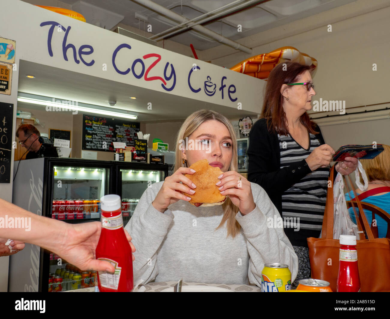 A young woman eats a full English breakfast in an indoor cafe Stock ...