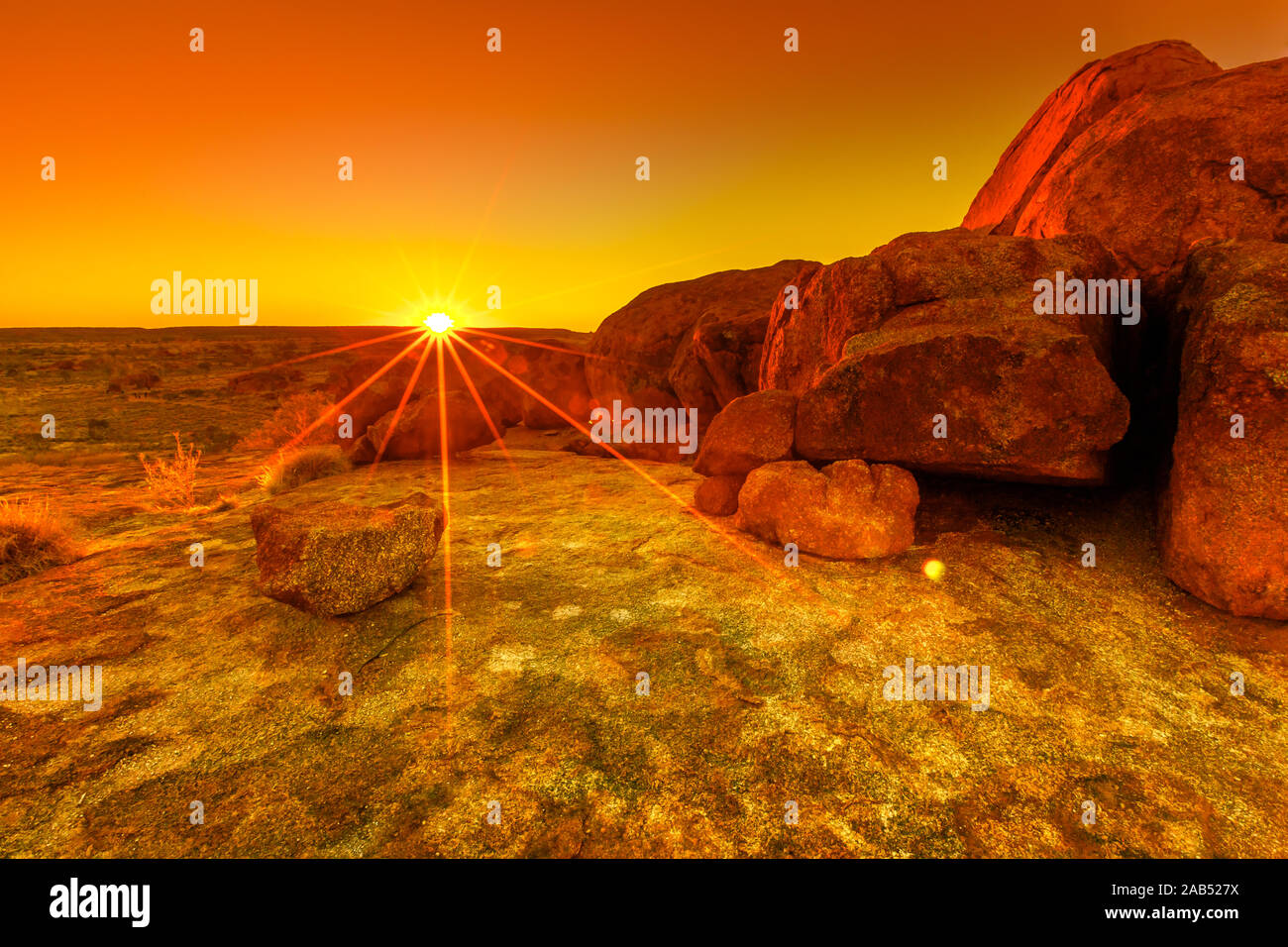 Vibrant orange and red colors of sunset sky over giant granite boulders ...