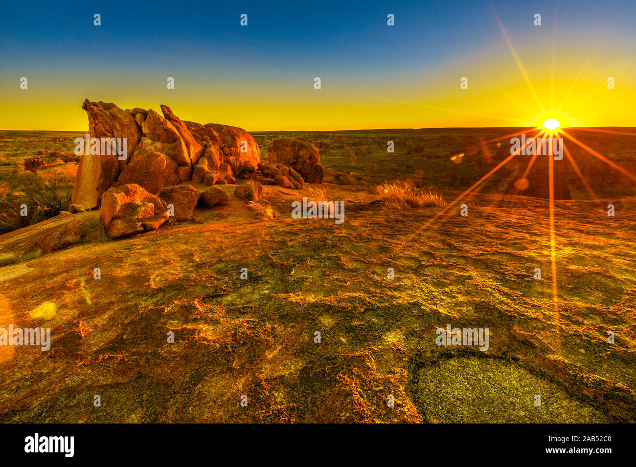 Sunbeams light and sunset colors sky over giant granite boulders at ...