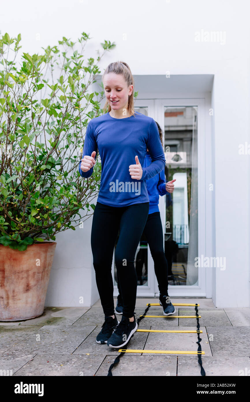 Two young women doing agility ladder exercise on a terrace Stock Photo ...