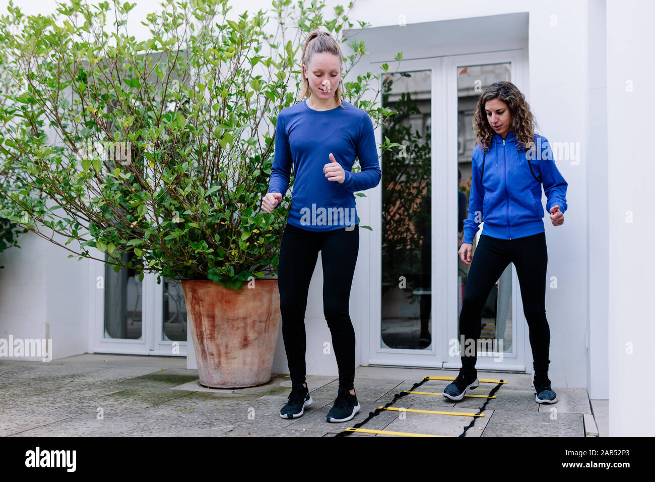 Two young women doing agility ladder exercise on a terrace Stock Photo ...